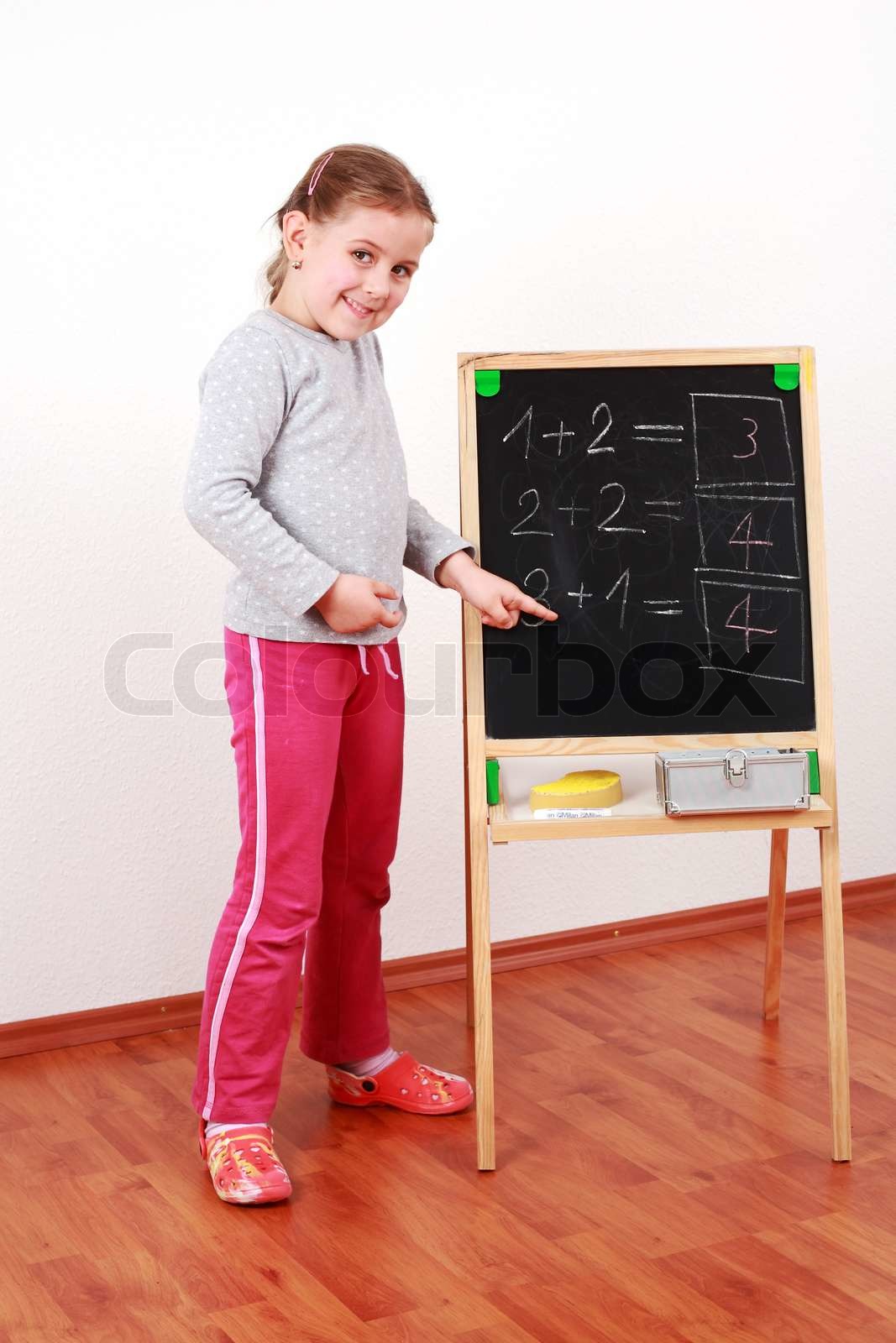 Cute girl doing the math on chalkborard | Stock image | Colourbox