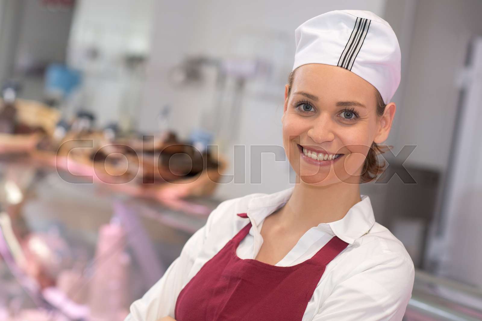 happy female butcher standing in shop | Stock image | Colourbox