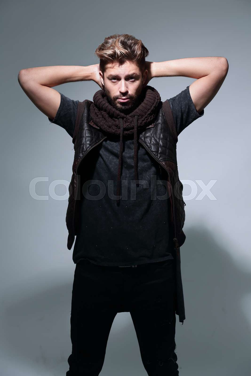 Handsome young man holding hands behind head | Stock image | Colourbox