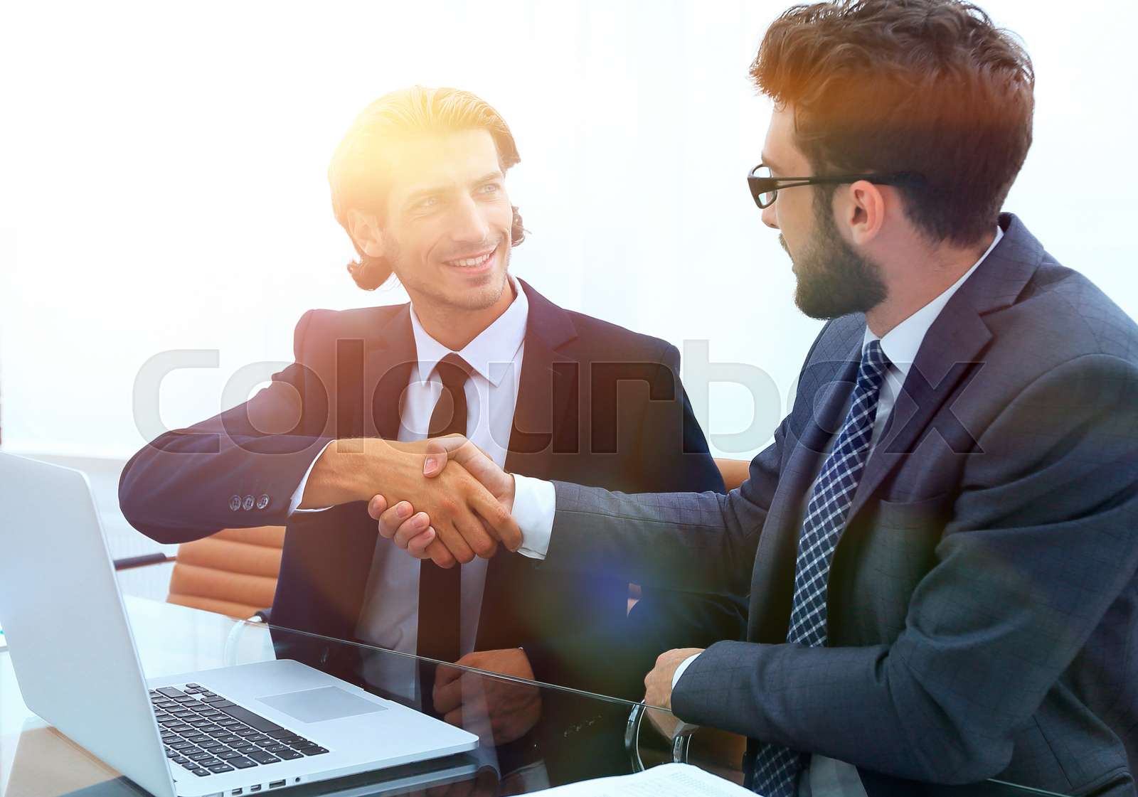handshake business man sitting behind a Desk. | Stock image | Colourbox
