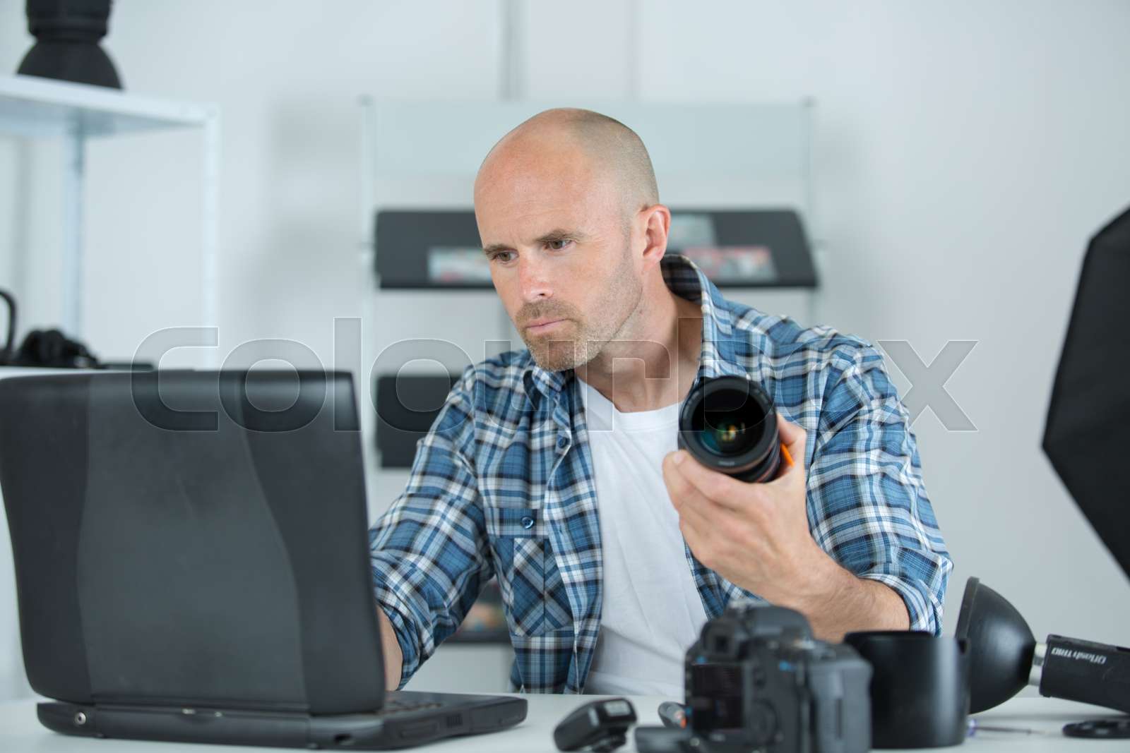 man holding camera while sitting at his working place | Stock image ...