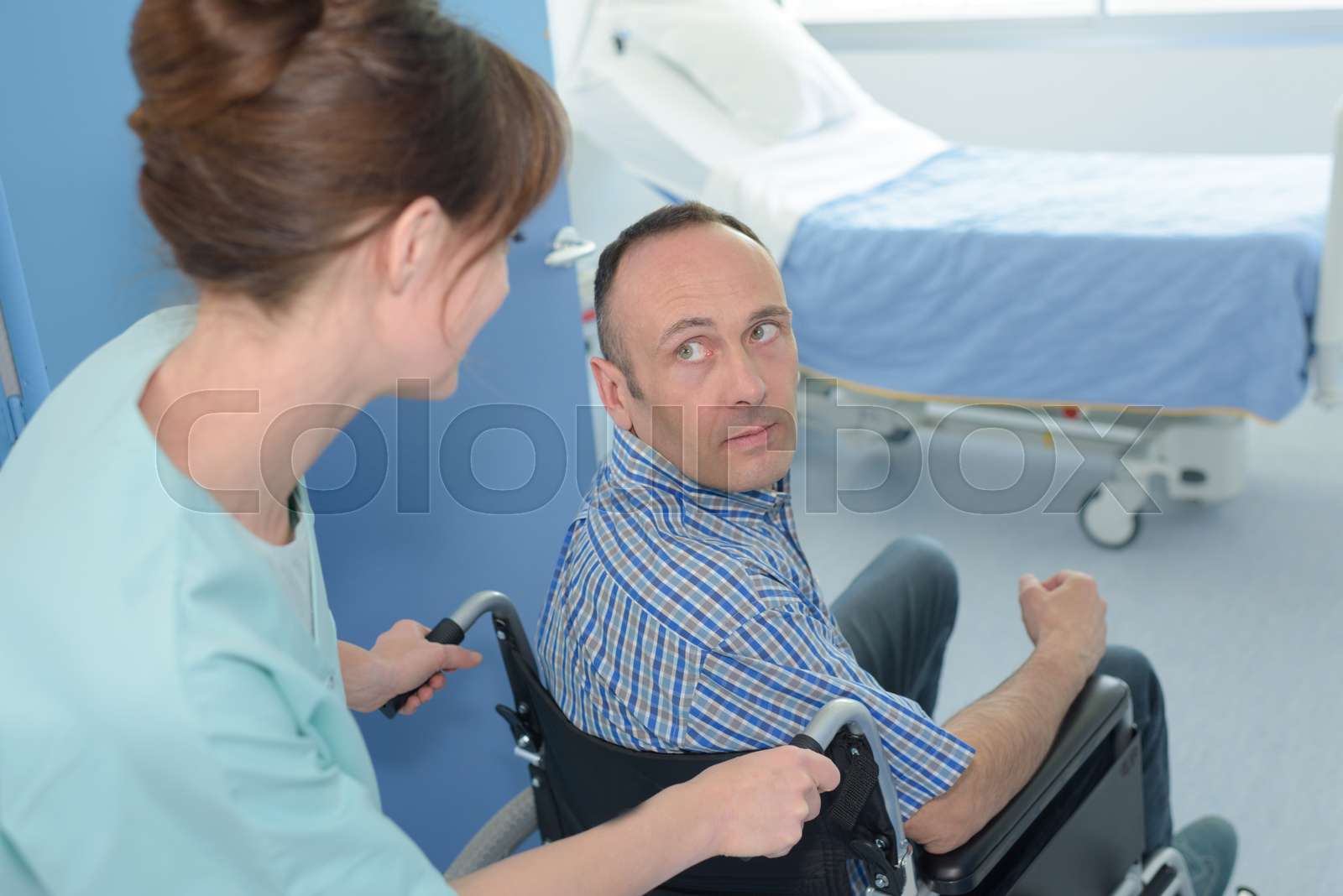 nurse pushing a patient on a wheelchair | Stock image | Colourbox