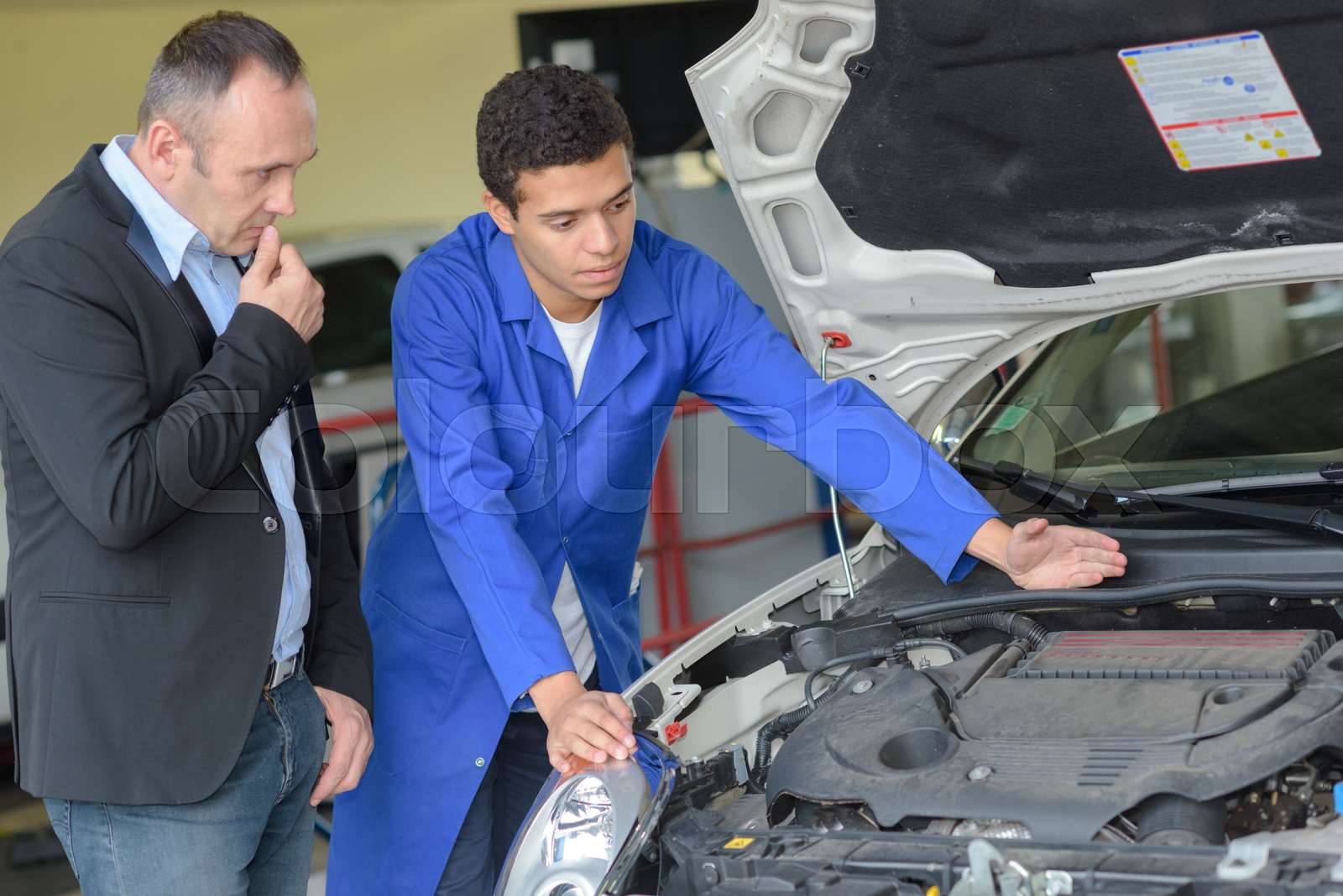 teacher helping student training to be car mechanics | Stock image ...