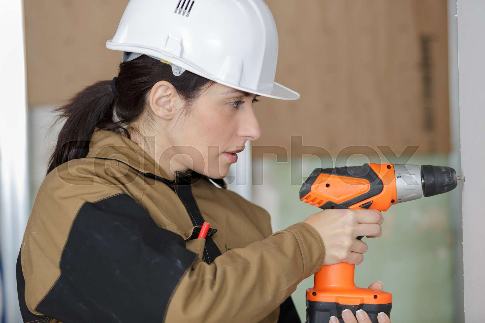 Professional woman using cordless drill | Stock image | Colourbox