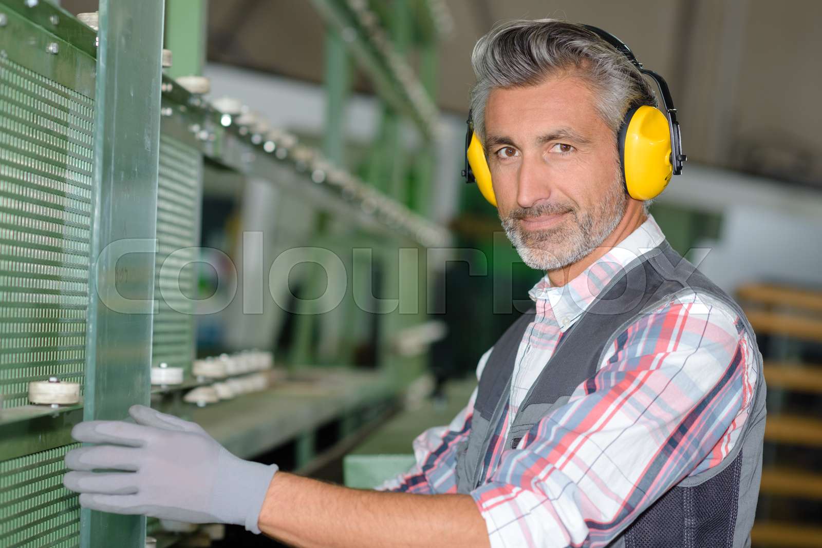 worker wearing hearing protection at a factory | Stock image | Colourbox