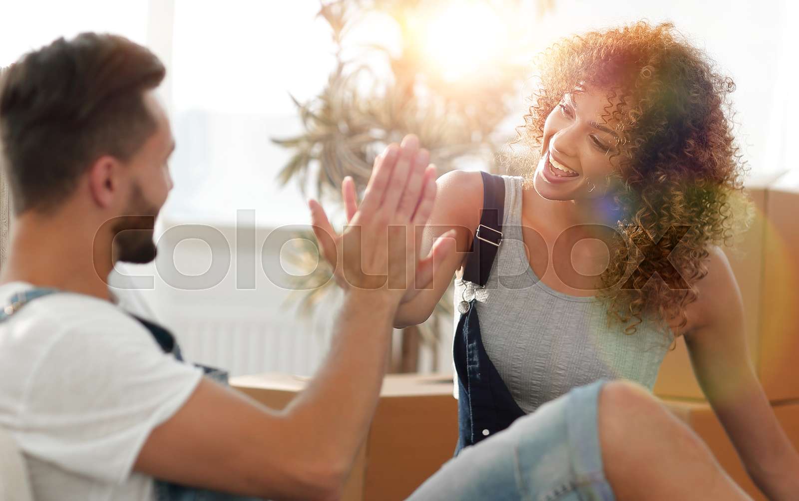 young couple giving each other five with a new home | Stock image ...