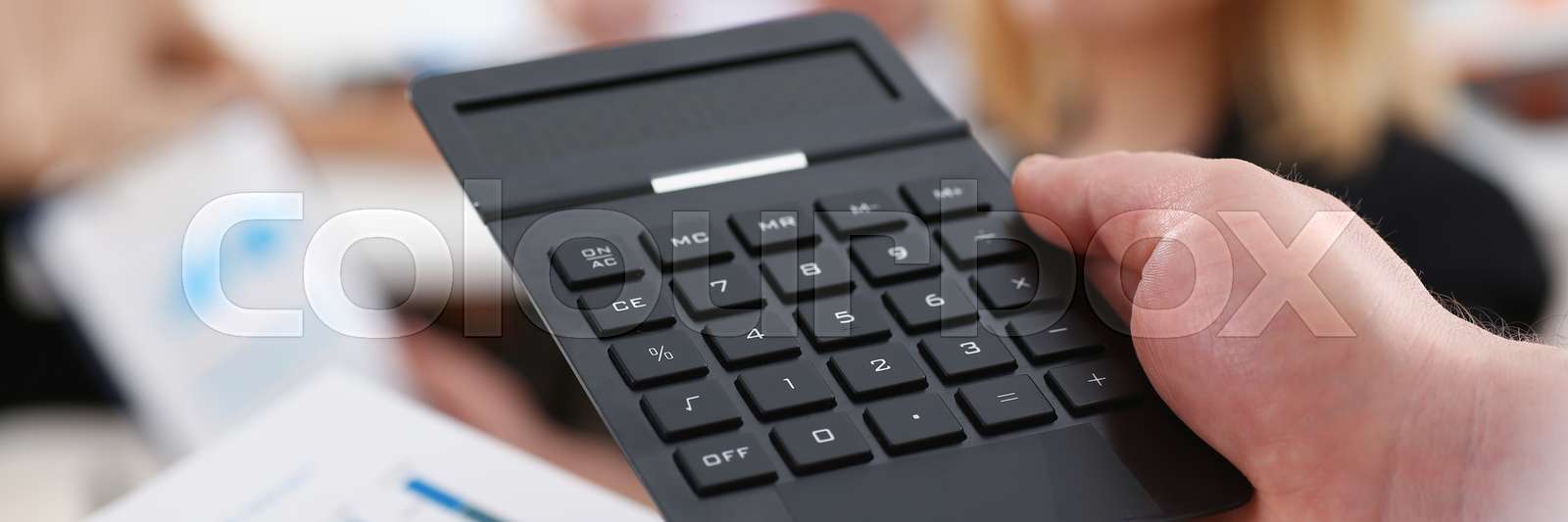 Male hand holding calculator at office | Stock image | Colourbox