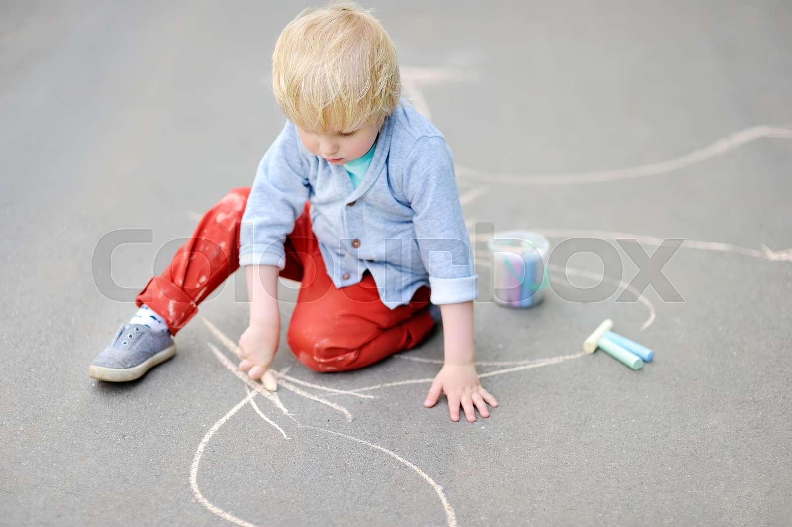Happy little kid boy drawing with colored chalk on asphalt. | Stock ...