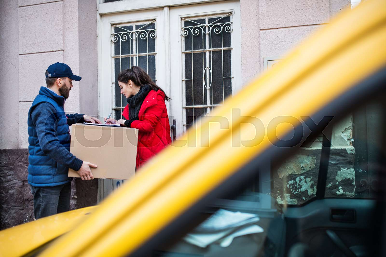 Woman receiving parcel from delivery man at the door. | Stock image ...