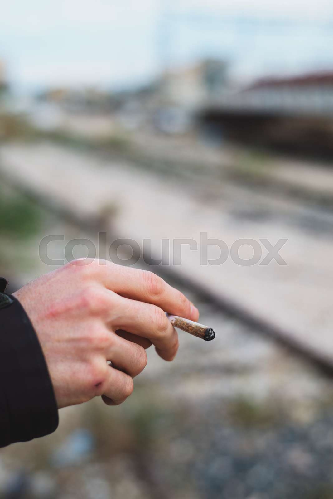 man smoking a hand-rolled cigarette or a joint | Stock image | Colourbox