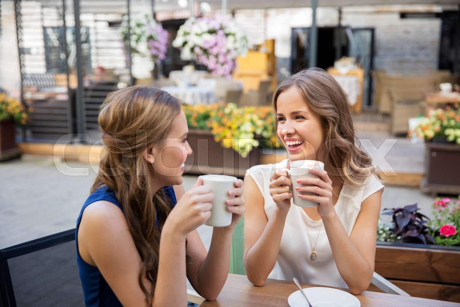 happy young women drinking coffee at outdoor cafe | Stock image | Colourbox