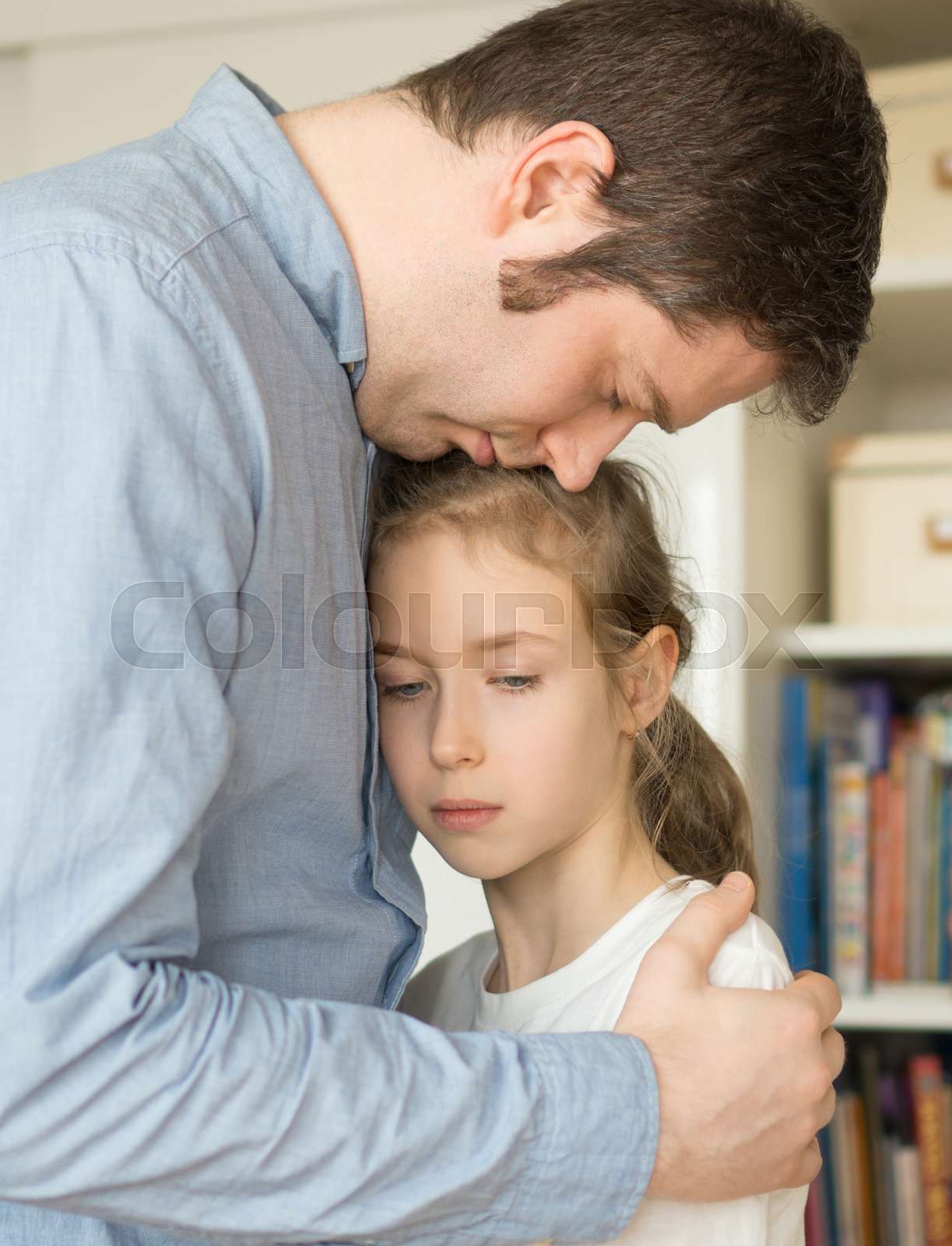 Sad little girl hugging her dad. | Stock image | Colourbox
