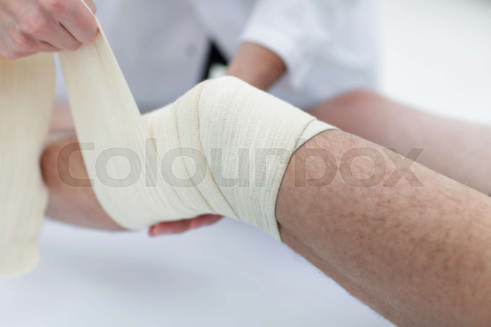 closeup. doctor bandaging a patient's leg | Stock image | Colourbox