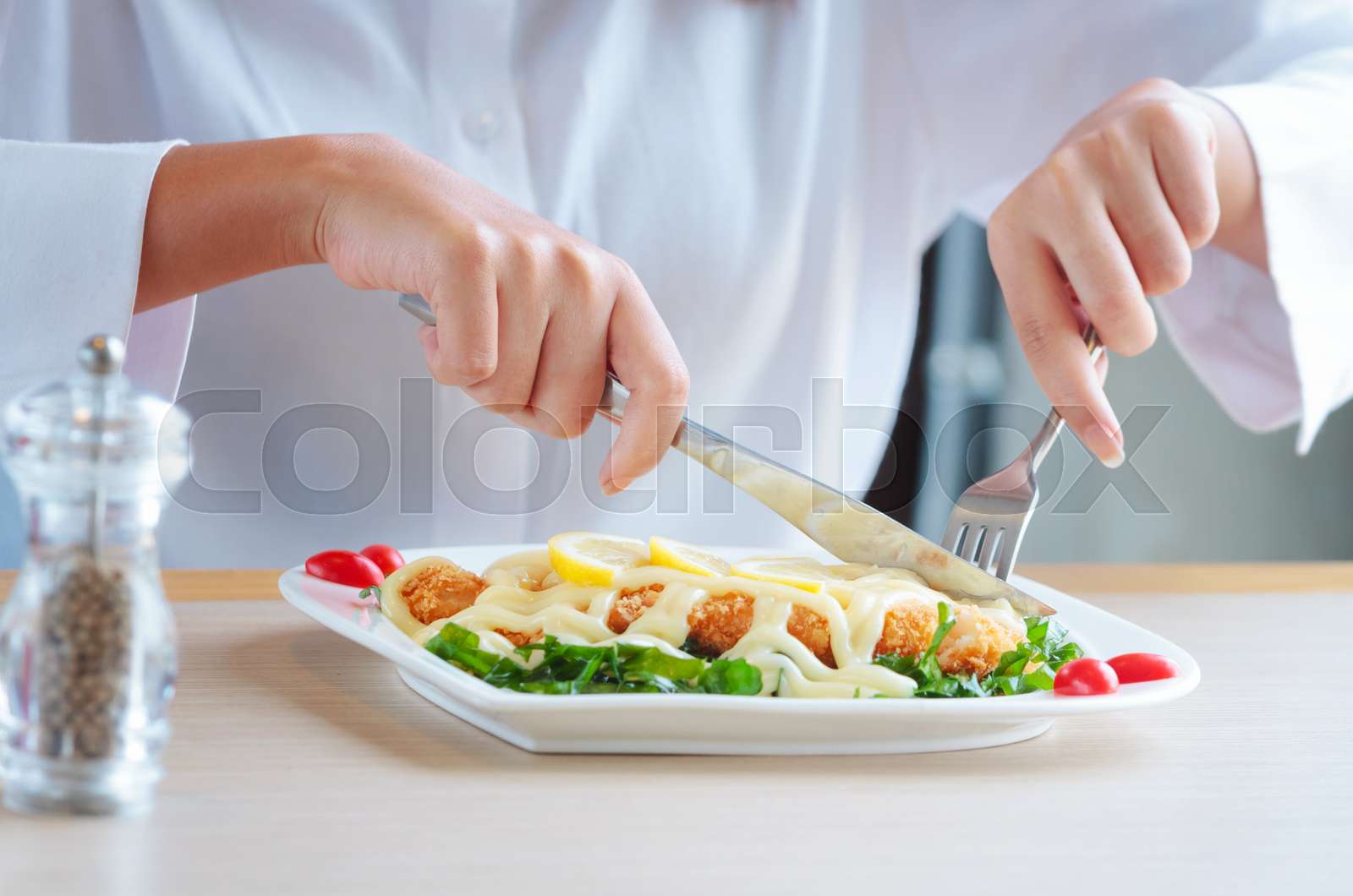 Woman hands cutting and eating delicious meal with knife and fork at ...
