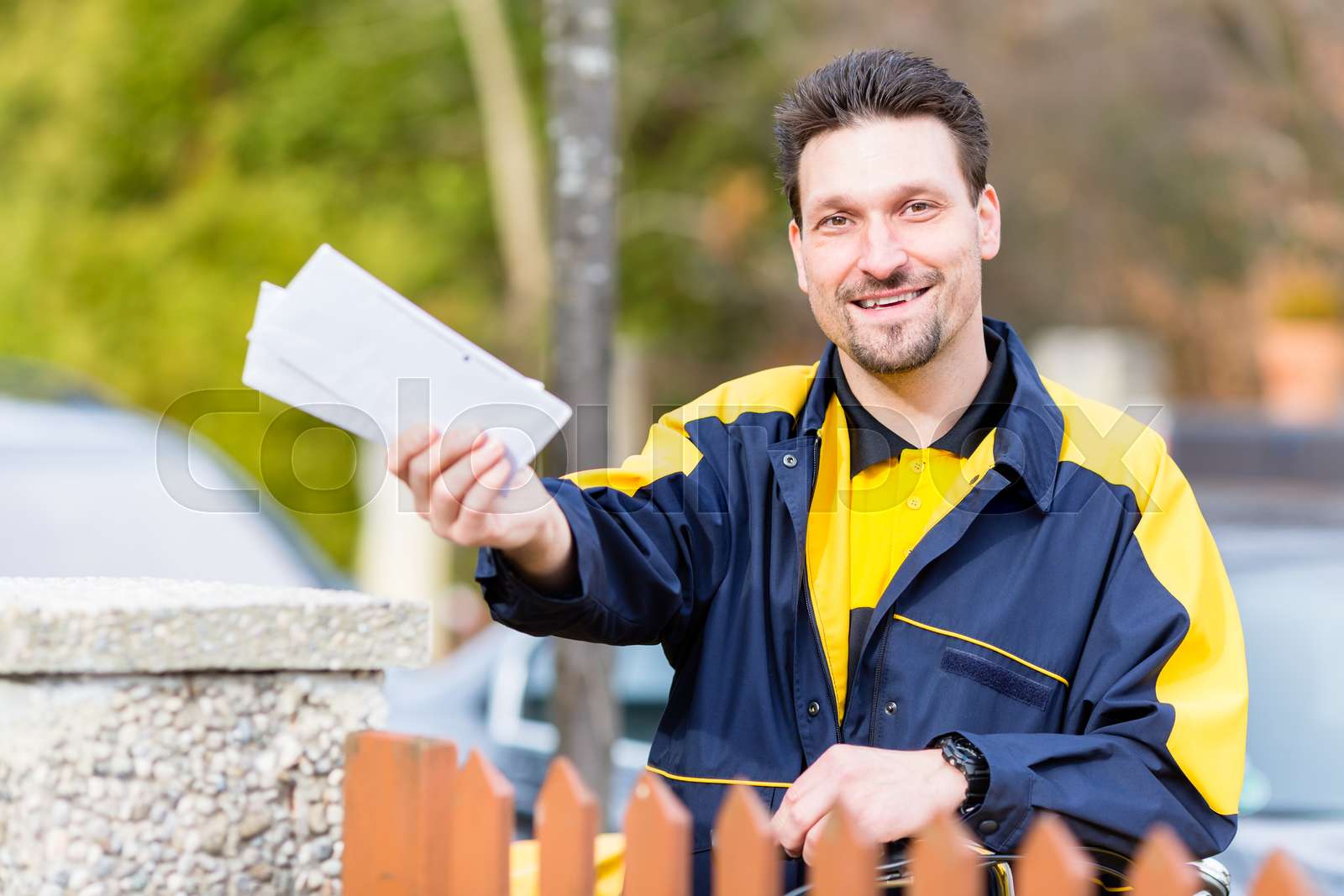Postman delivering letters to mailbox of recipient | Stock image ...