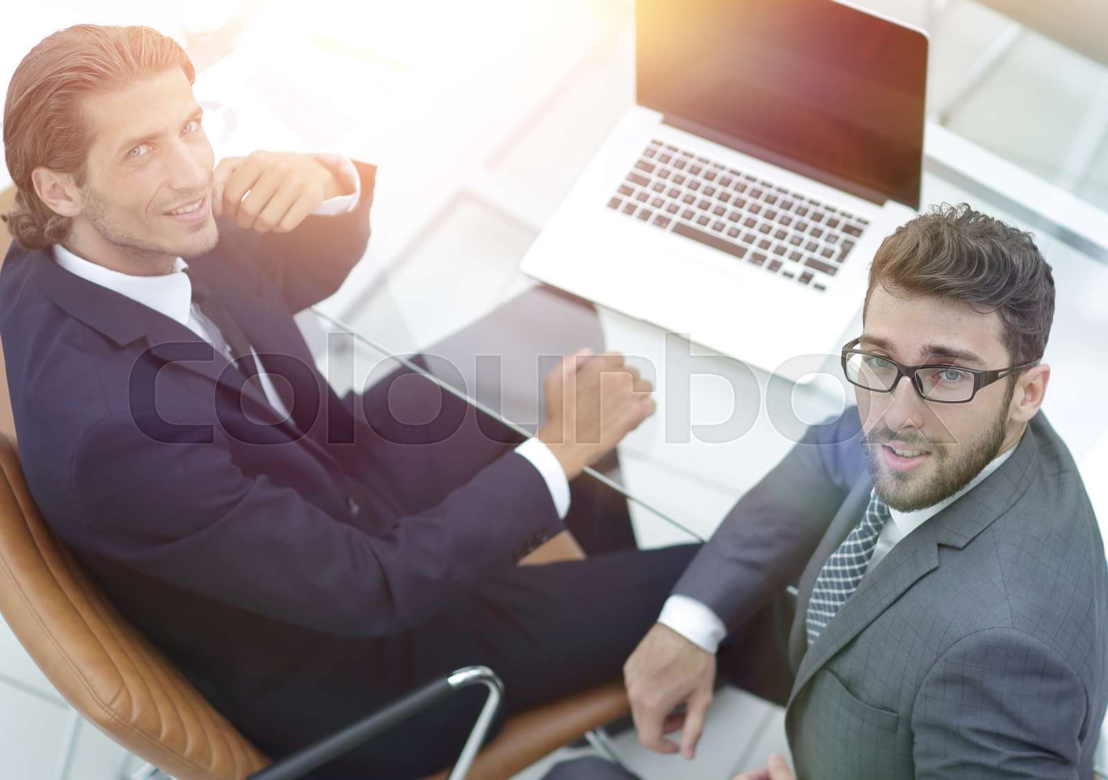 successful employees sitting behind a Desk | Stock image | Colourbox