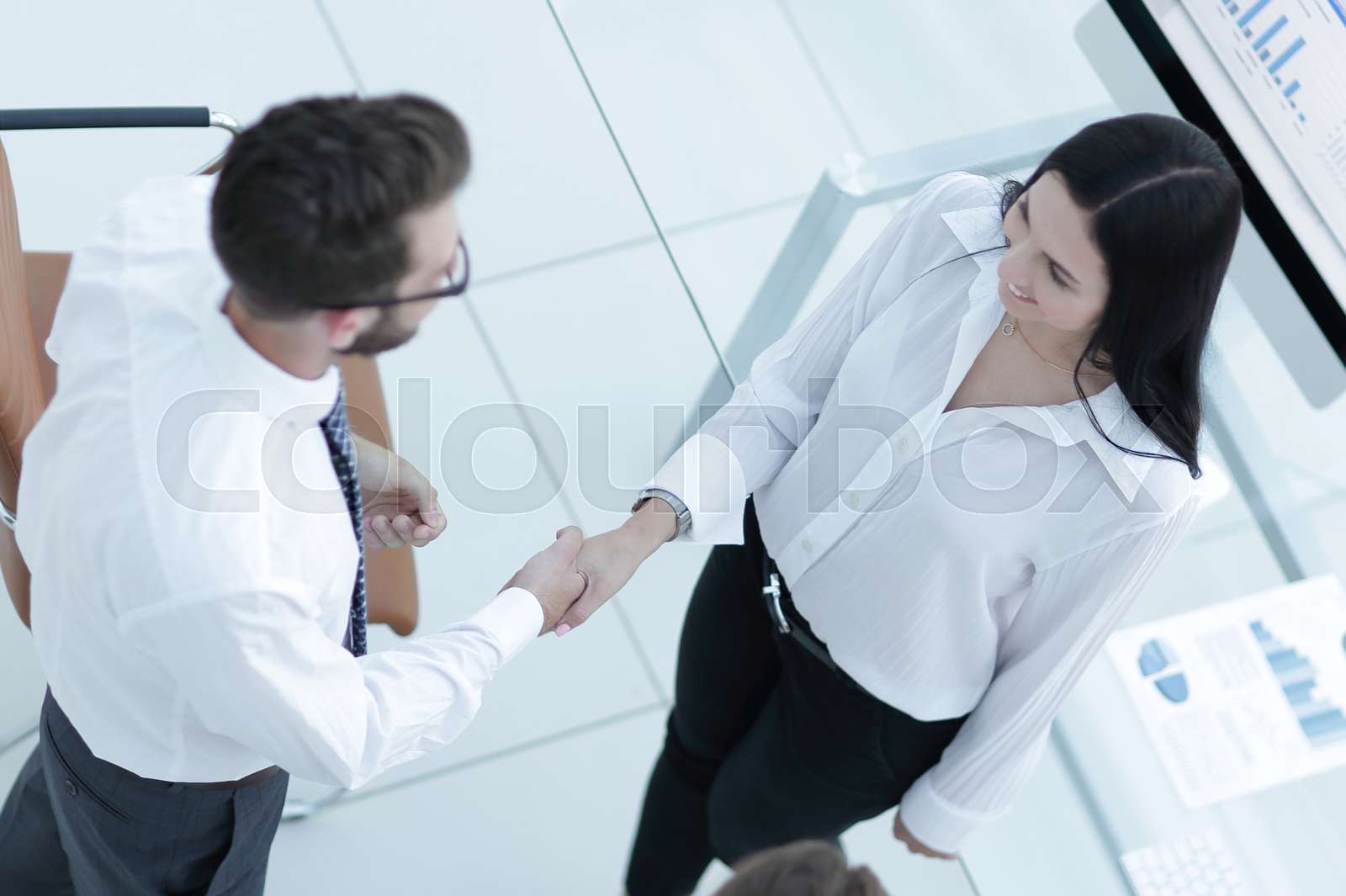 handshake manager and employee near the workplace | Stock image | Colourbox