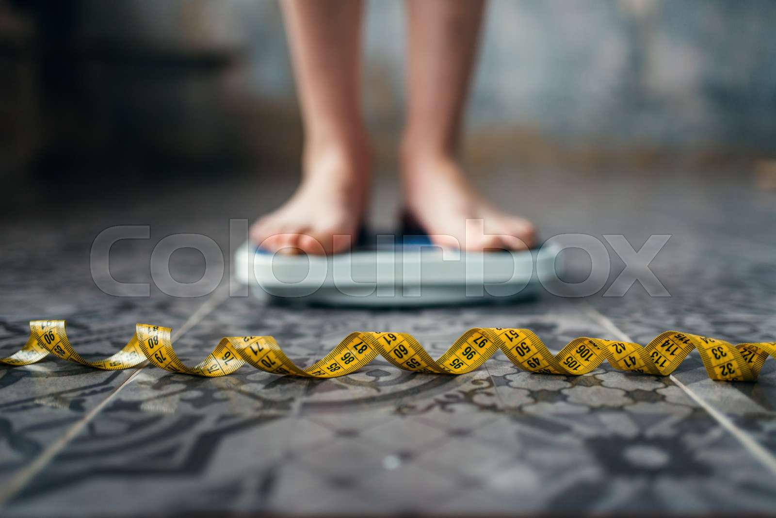 Female feet on the scales, measuring tape | Stock image | Colourbox