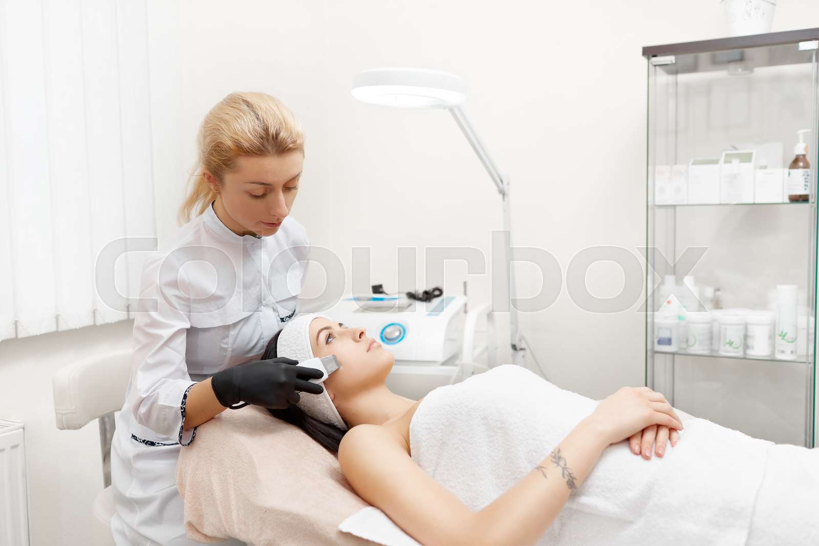 Attractive woman getting facial in modern beauty salon. | Stock image ...