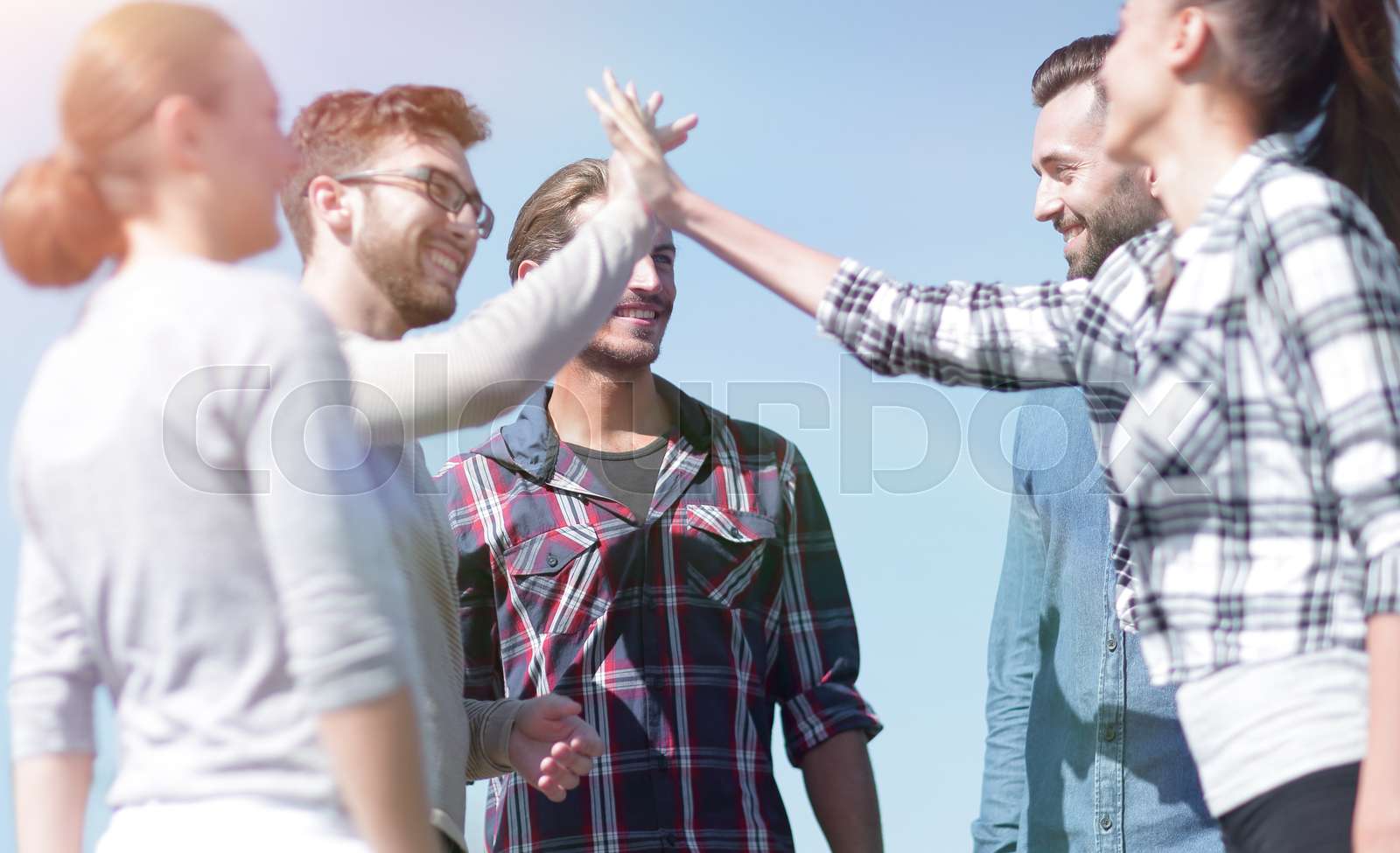 friends greet each other, giving a high five. | Stock image | Colourbox