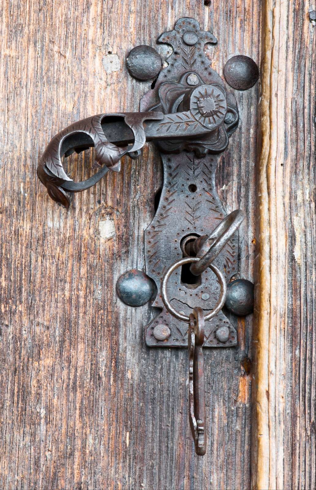 An old metal handle and keys at wooden door | Stock image | Colourbox
