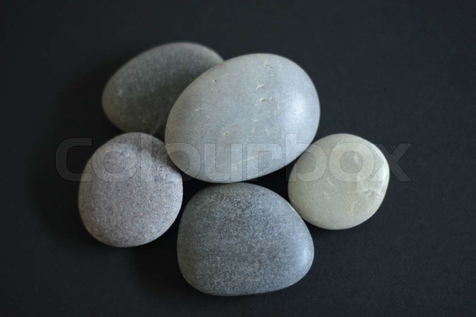 Samling af runde, glatte grå sten på sort baggrund | Stock foto | Colourbox