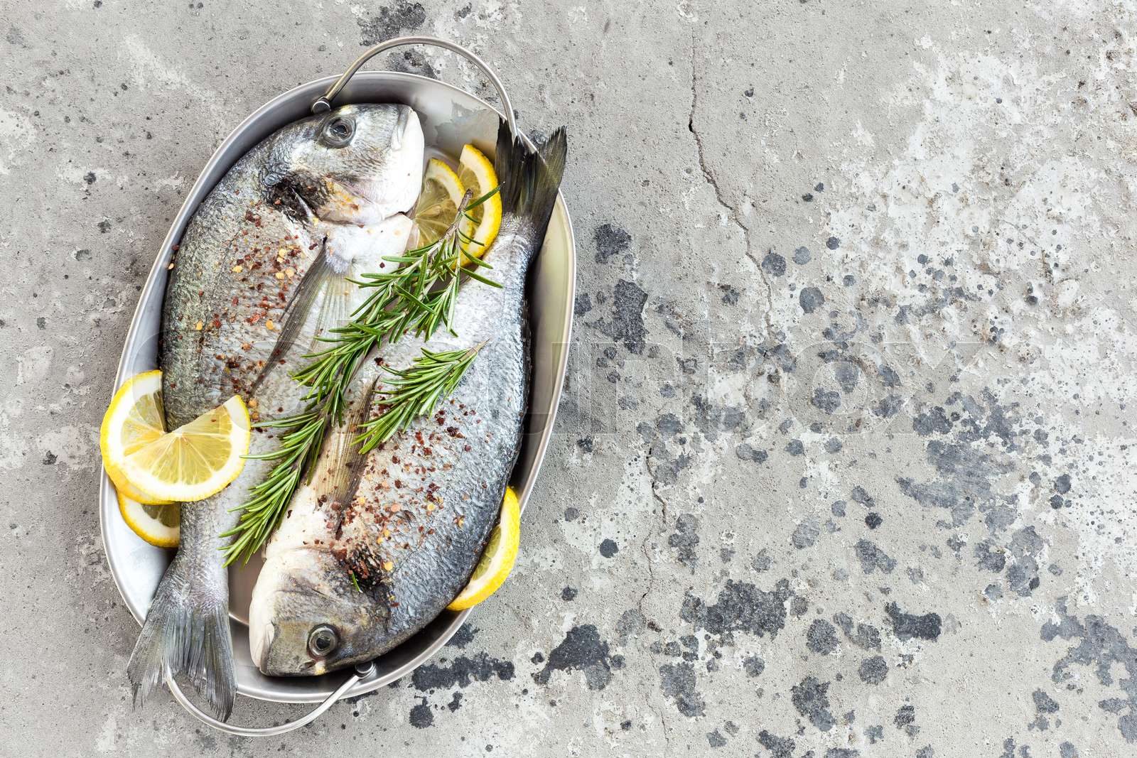 Fresh fish dorado. Raw dorado fish with lemon and rosemary. Sea bream ...