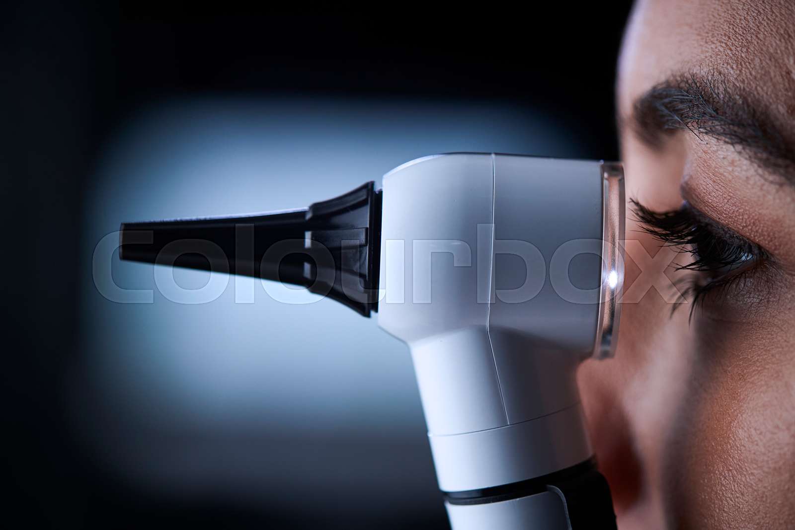 Female doctor using otoscope, side view, close up | Stock image | Colourbox