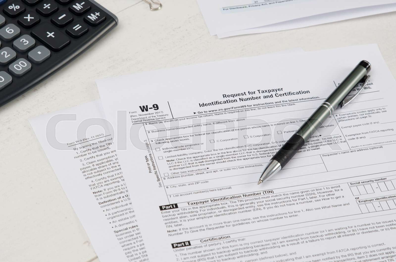 US tax form W-9 with pen and calculator | Stock image | Colourbox