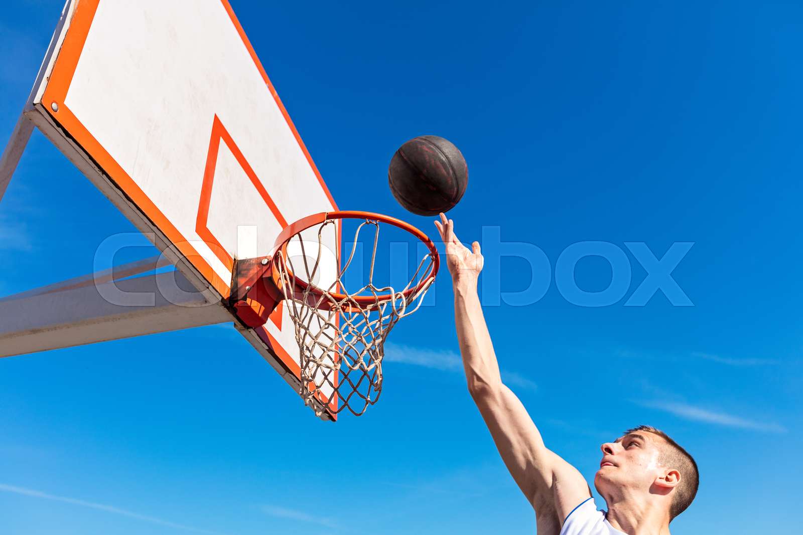Slam Dunk. Side view of young basketball player making slam dunk ...