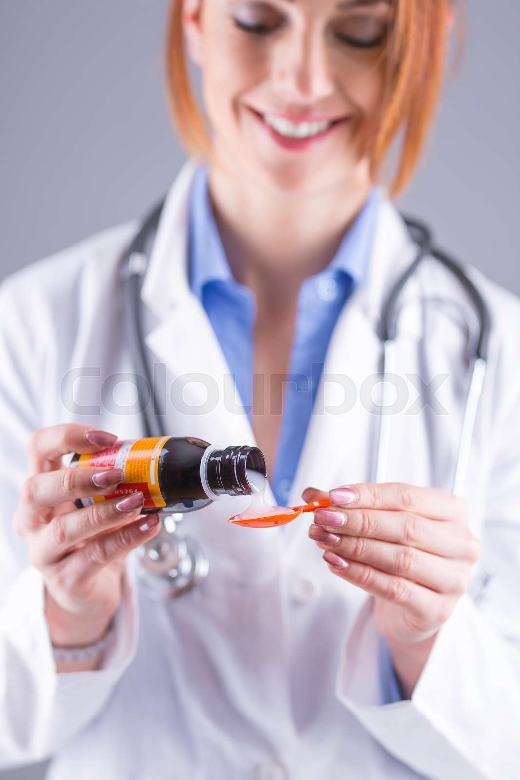 Hands of young woman doctor pouring medicinal syrup on spoon | Stock ...