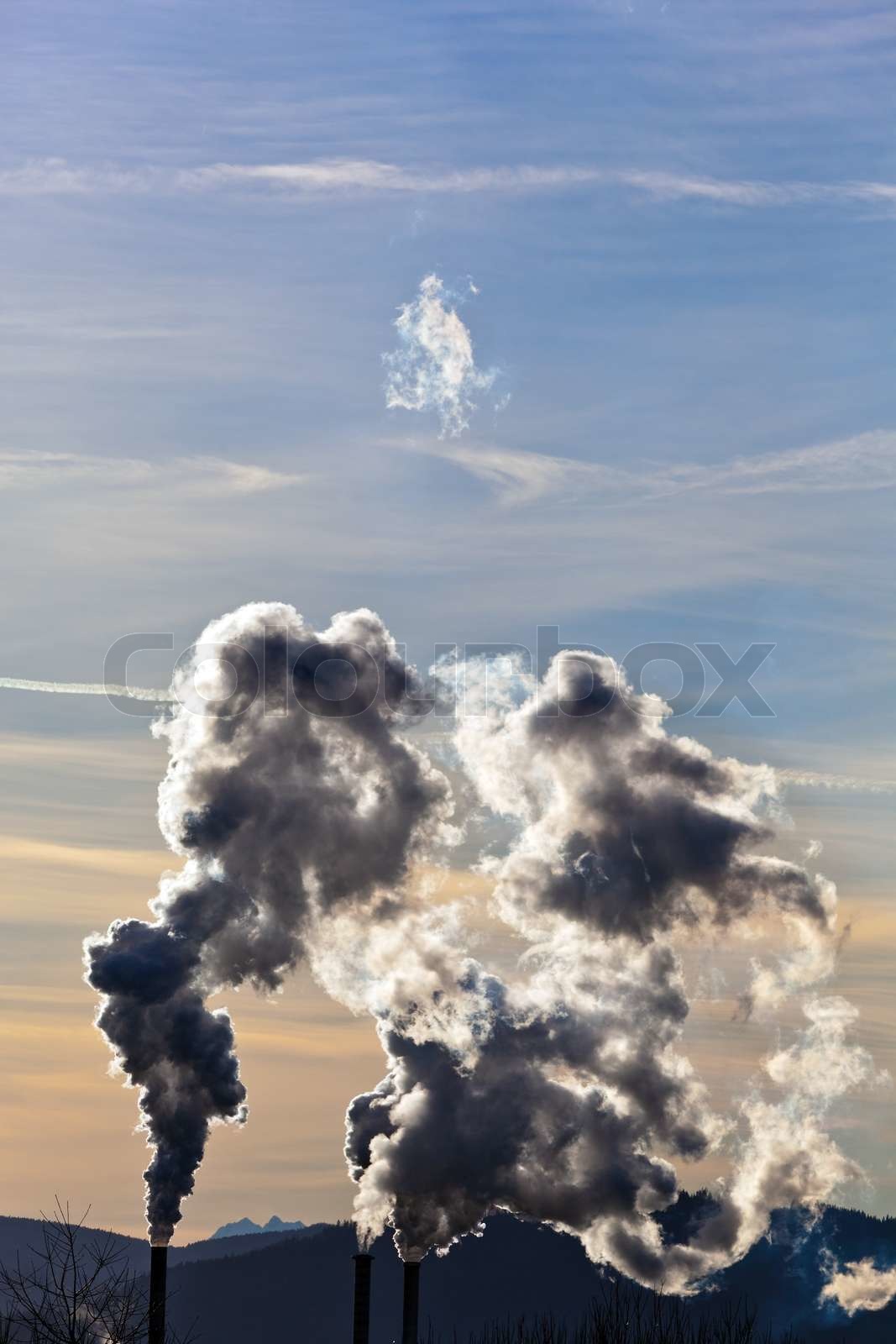 die rauchenden Schornsteine der Fabrik vor einem blauen Himmel weißer ...