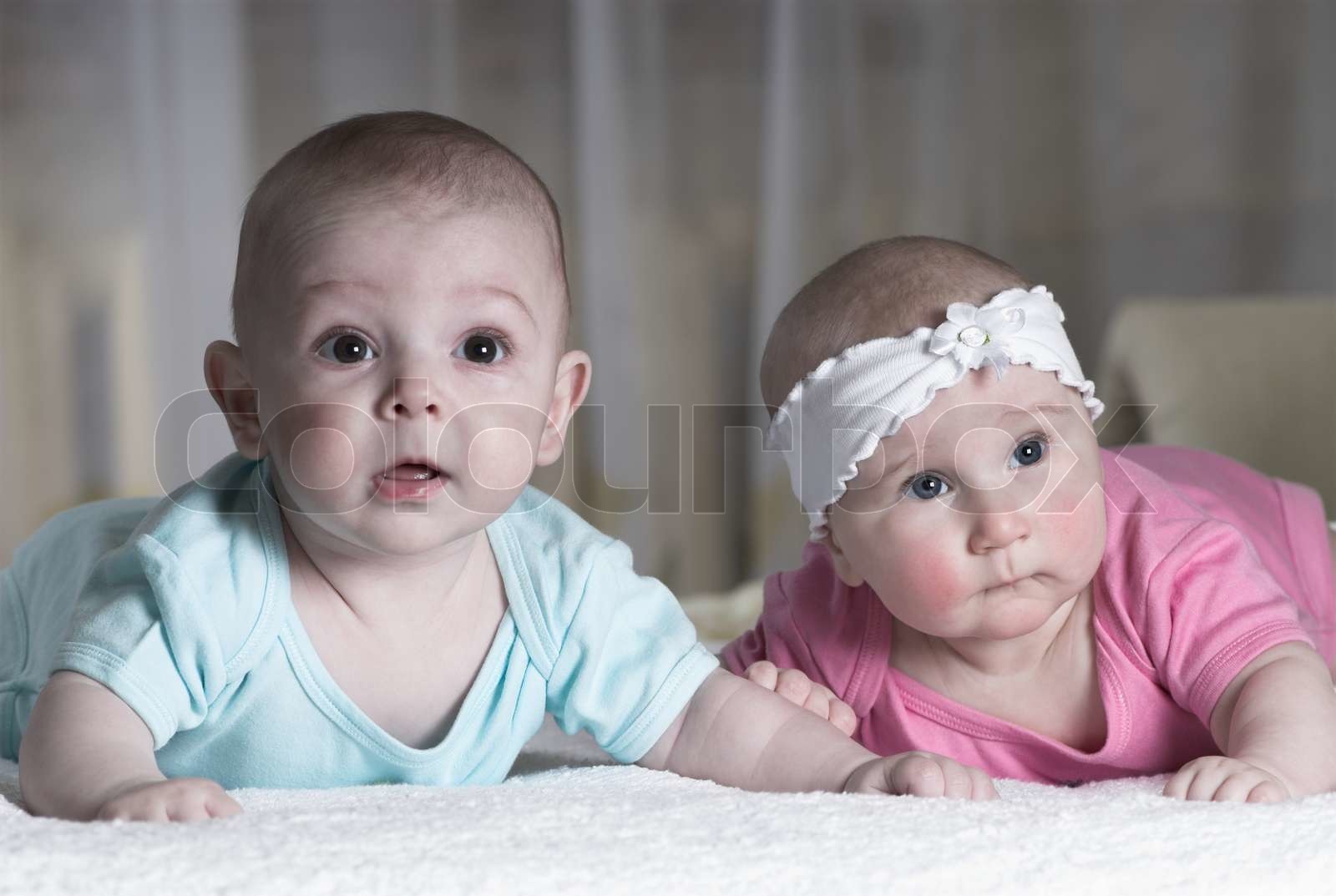 Two little babies is lying in bed. Toned image. | Stock image | Colourbox