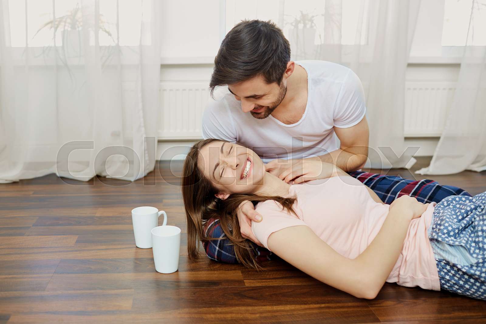 Young couple are hugging happily on the floor in the morning. | Stock ...