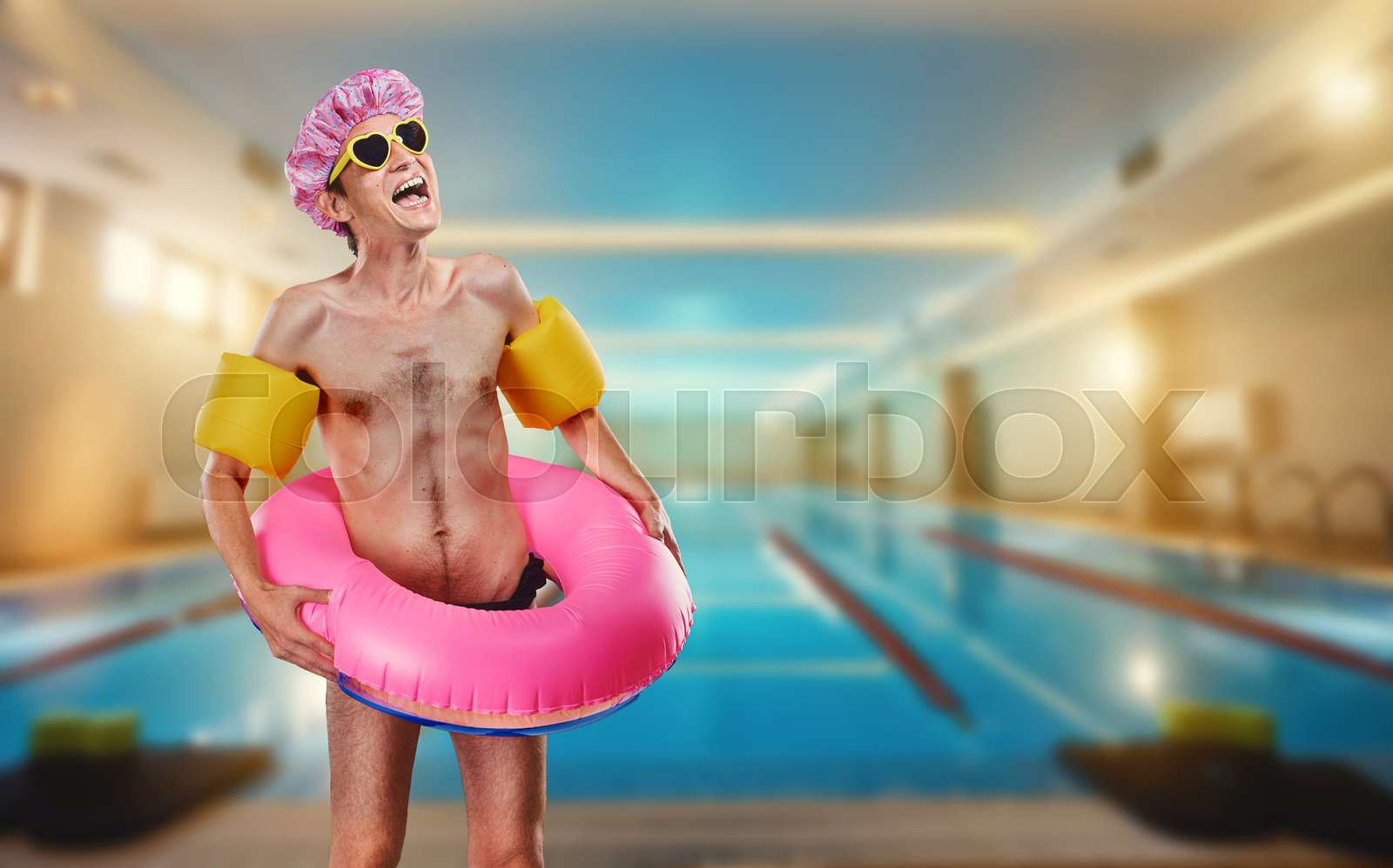A thin, funny man naked with a ring around the pool | Stock image | Colourbox