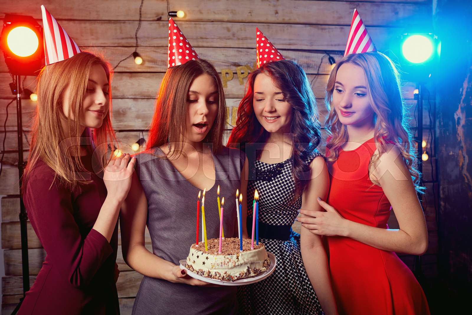 Birthday party girlfriends. Women light candles on the cake with ...