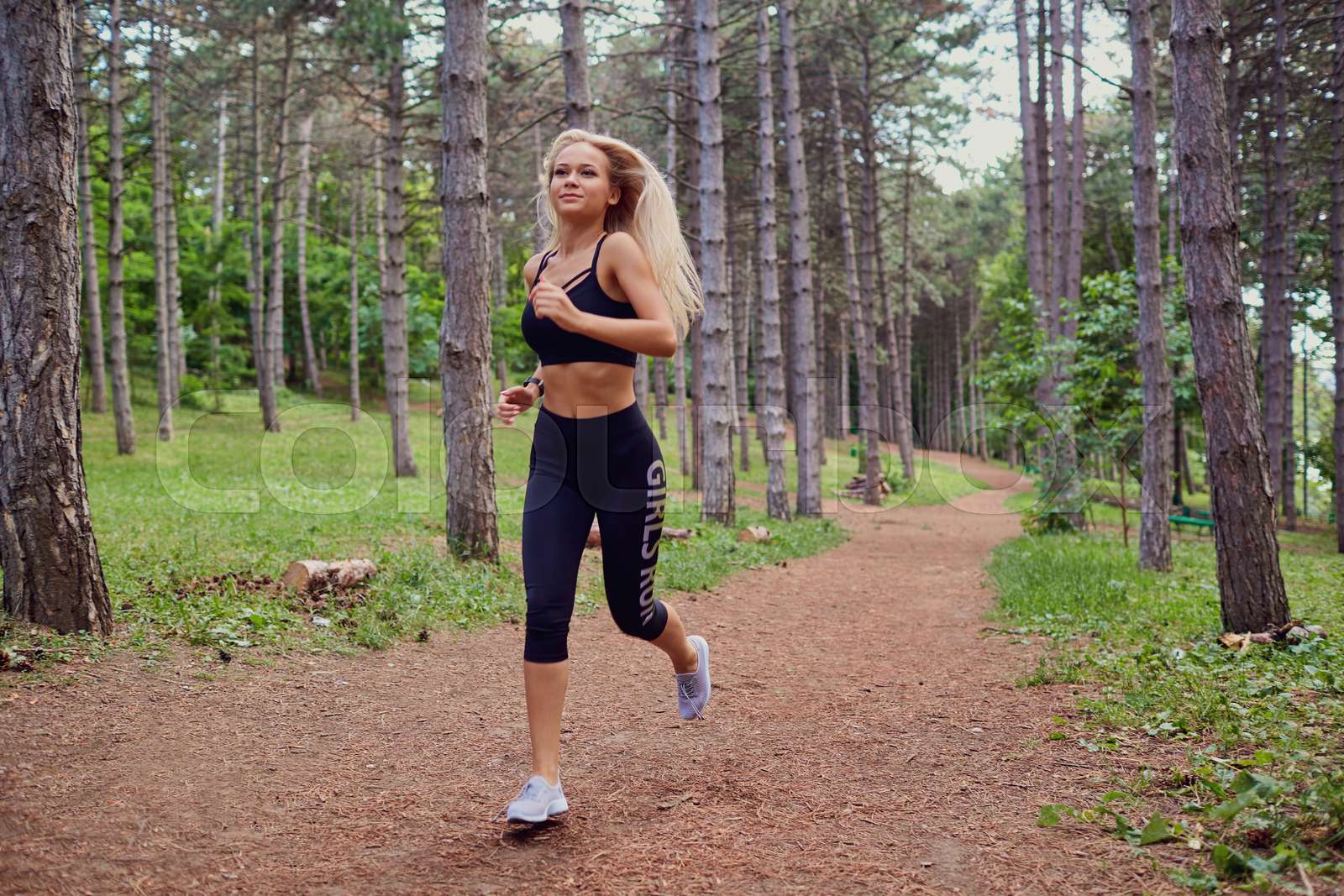 A woman runs jogging through the forest | Stock image | Colourbox