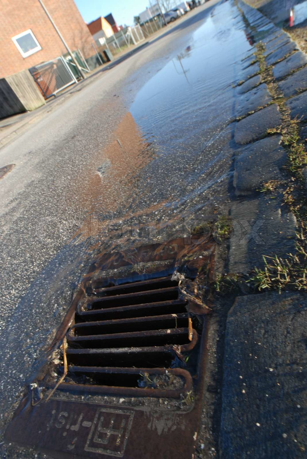 Drain. Water is running into a drain | Stock image | Colourbox