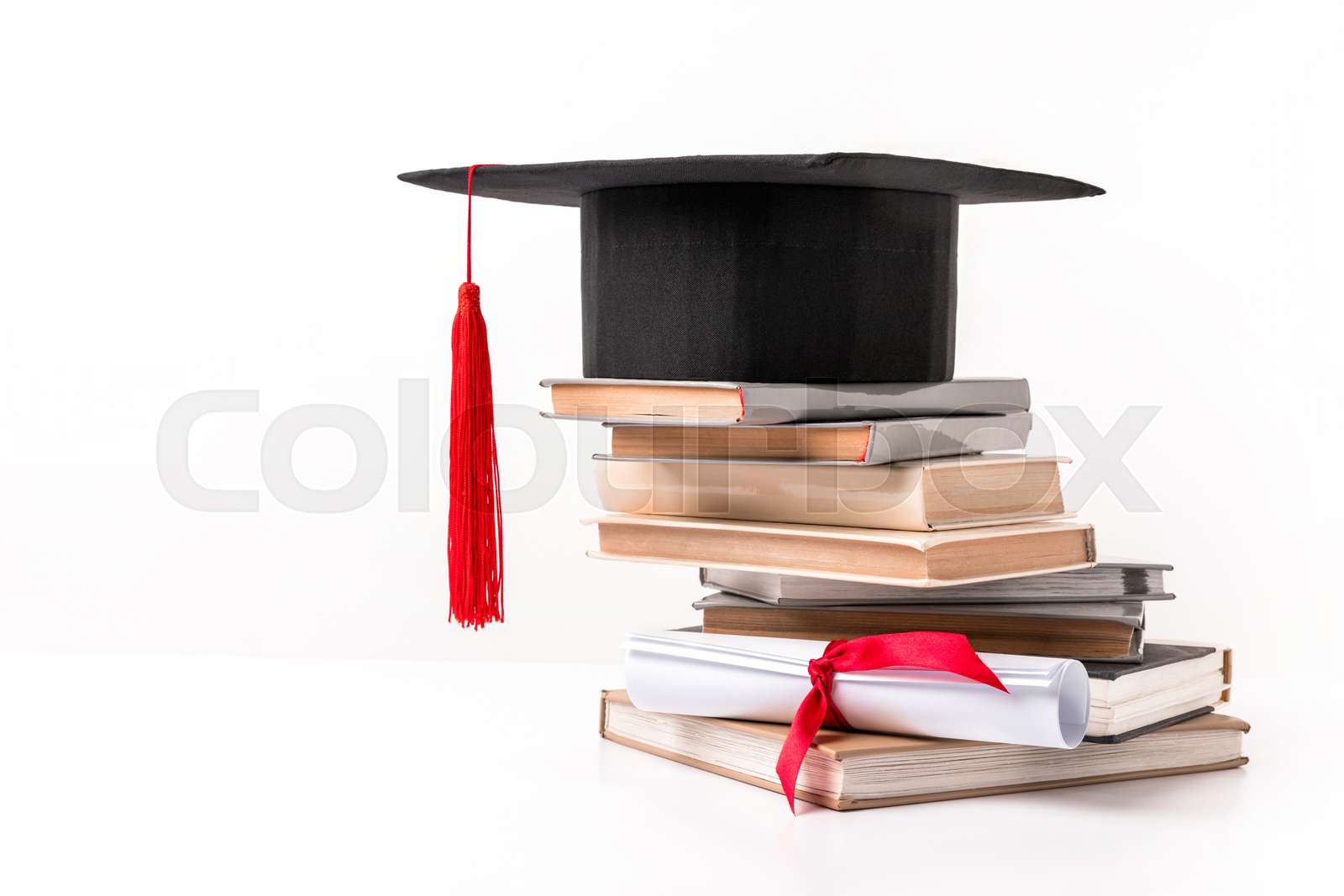 Academic cap on stack of books isolated on white | Stock image | Colourbox