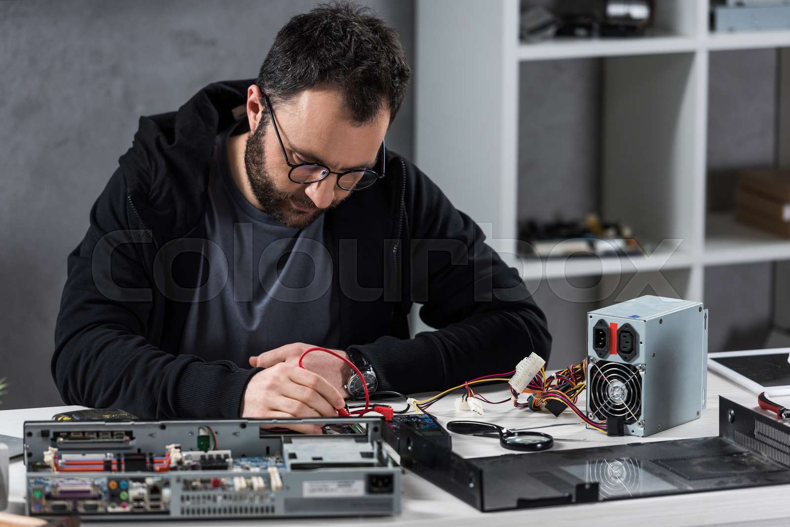 man using multimeter while fixing broken pc | Stock image | Colourbox