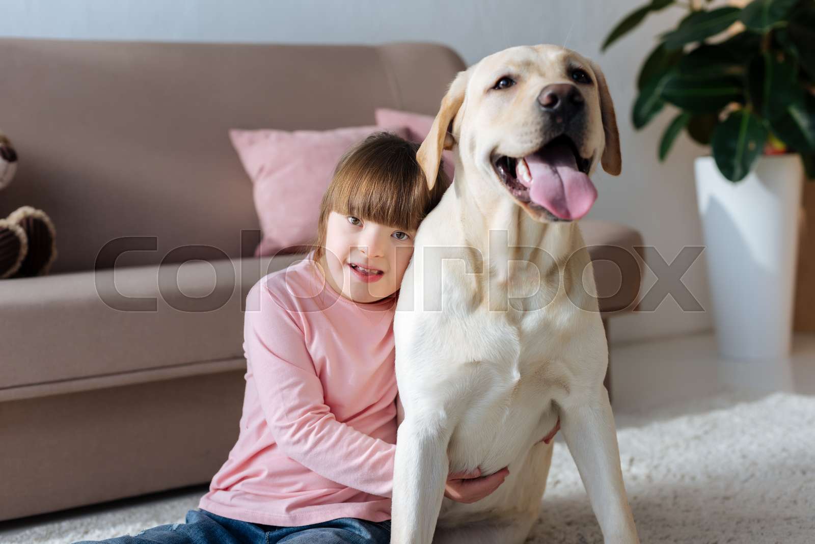 Kid with down syndrome embracing Labrador retriever | Stock image ...