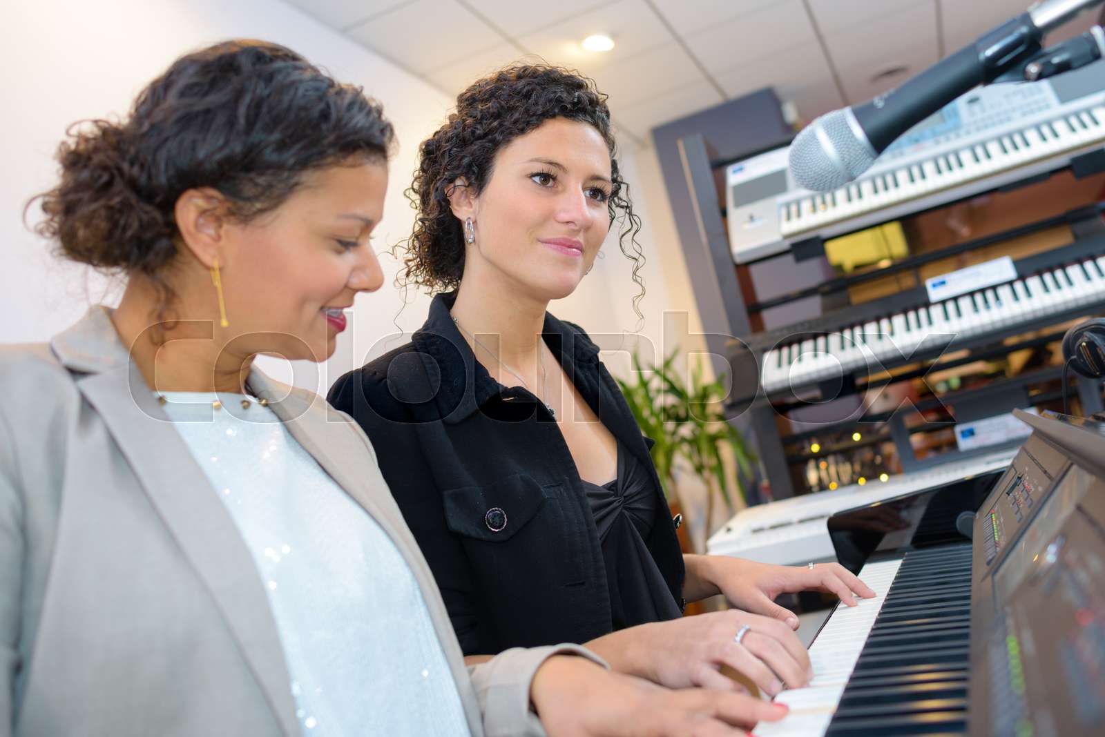 Two women playing keyboard | Stock image | Colourbox