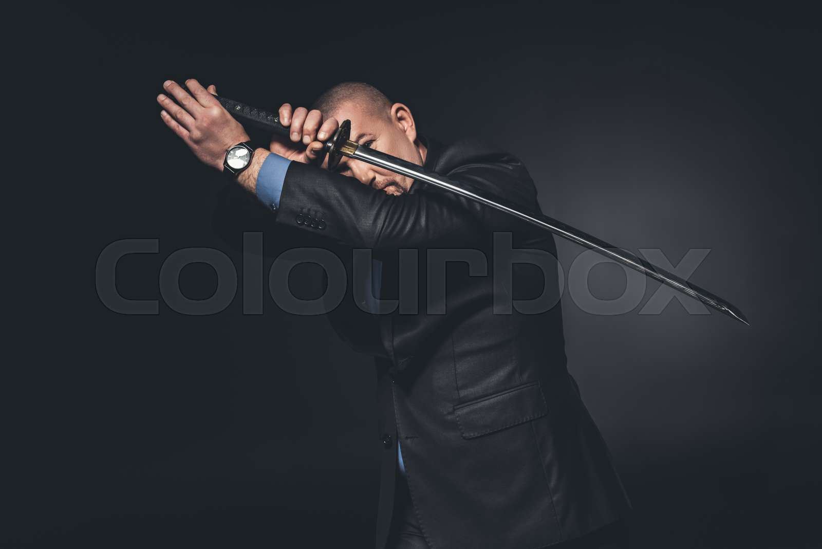 man in suit fighting with katana sword on black | Stock image | Colourbox