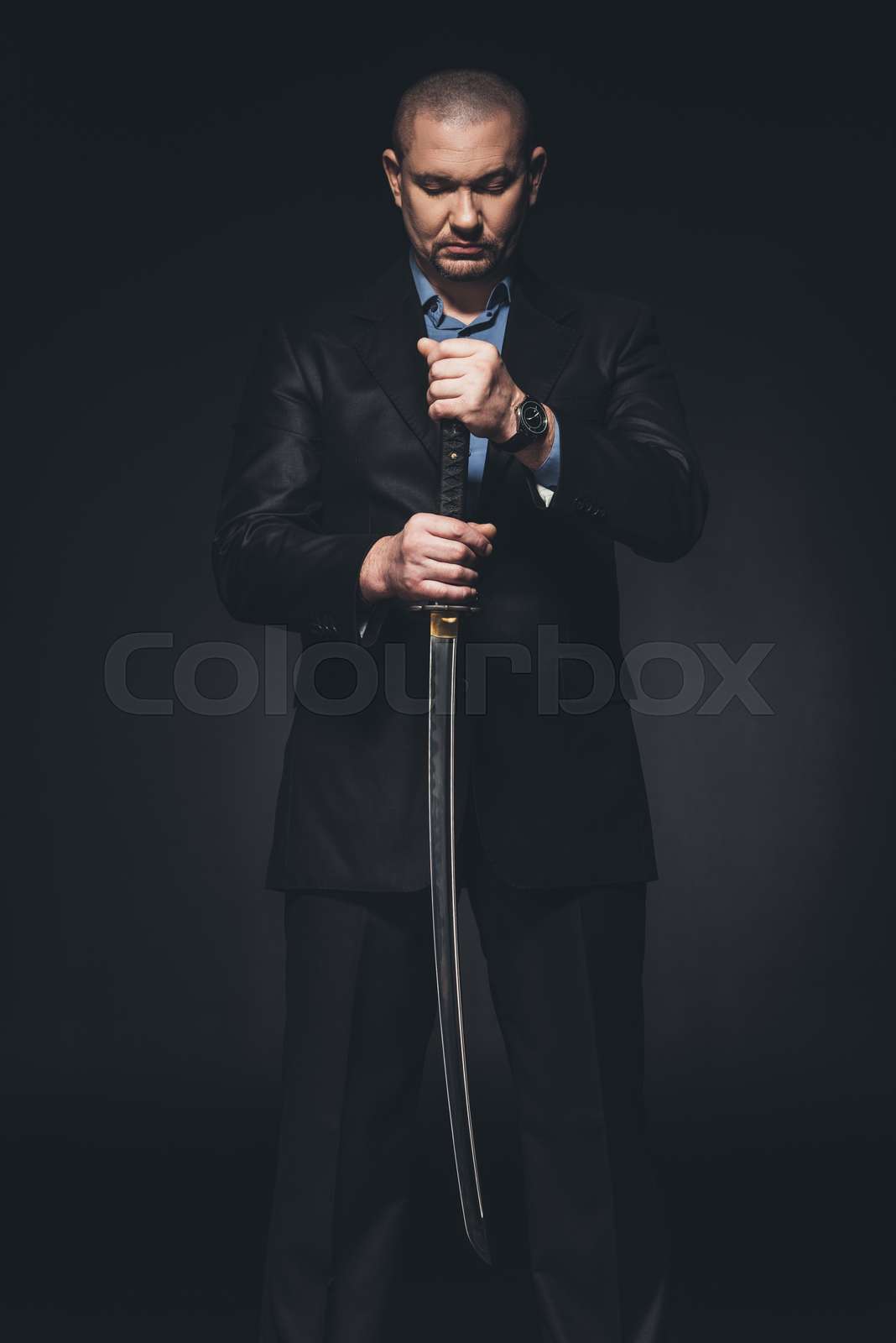 man in suit with japanese katana sword on black | Stock image | Colourbox