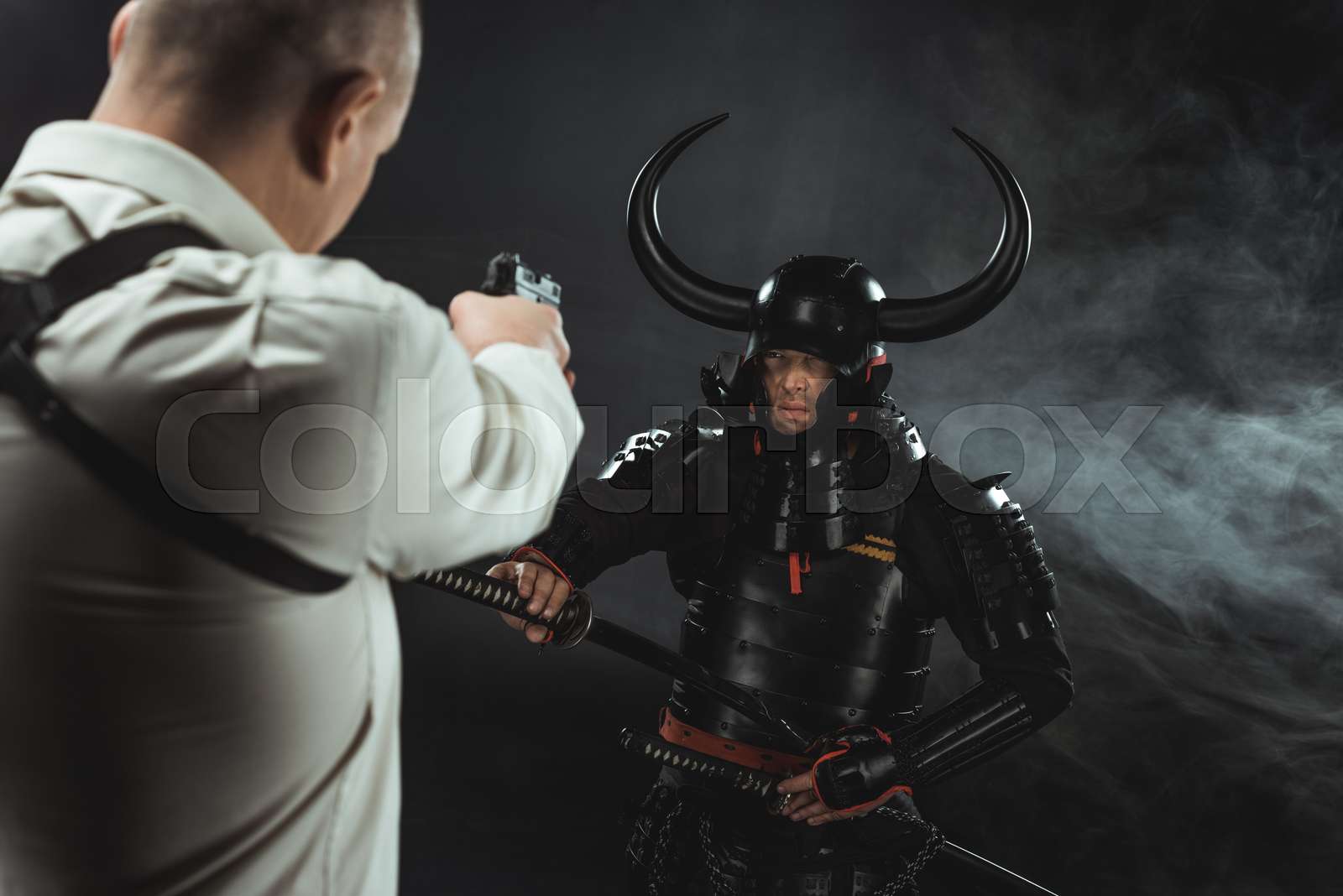 man aiming on armored samurai with gun | Stock image | Colourbox