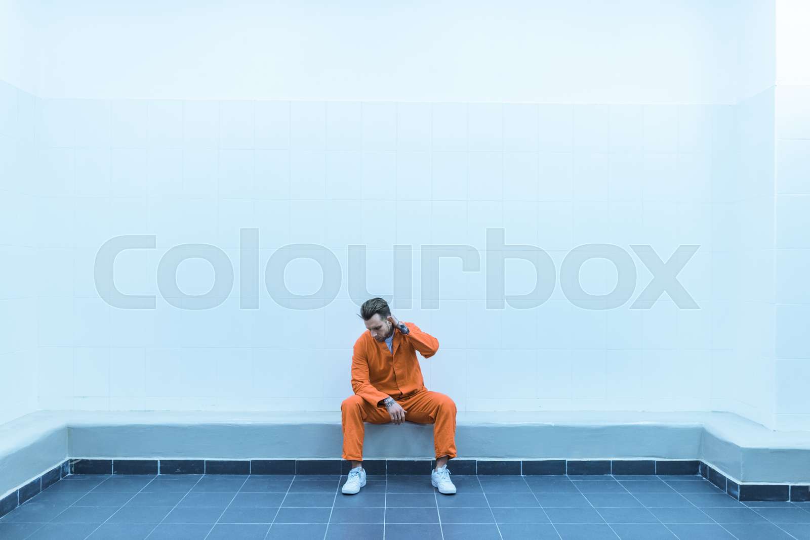 prisoner sitting on bench in prison cell | Stock image | Colourbox