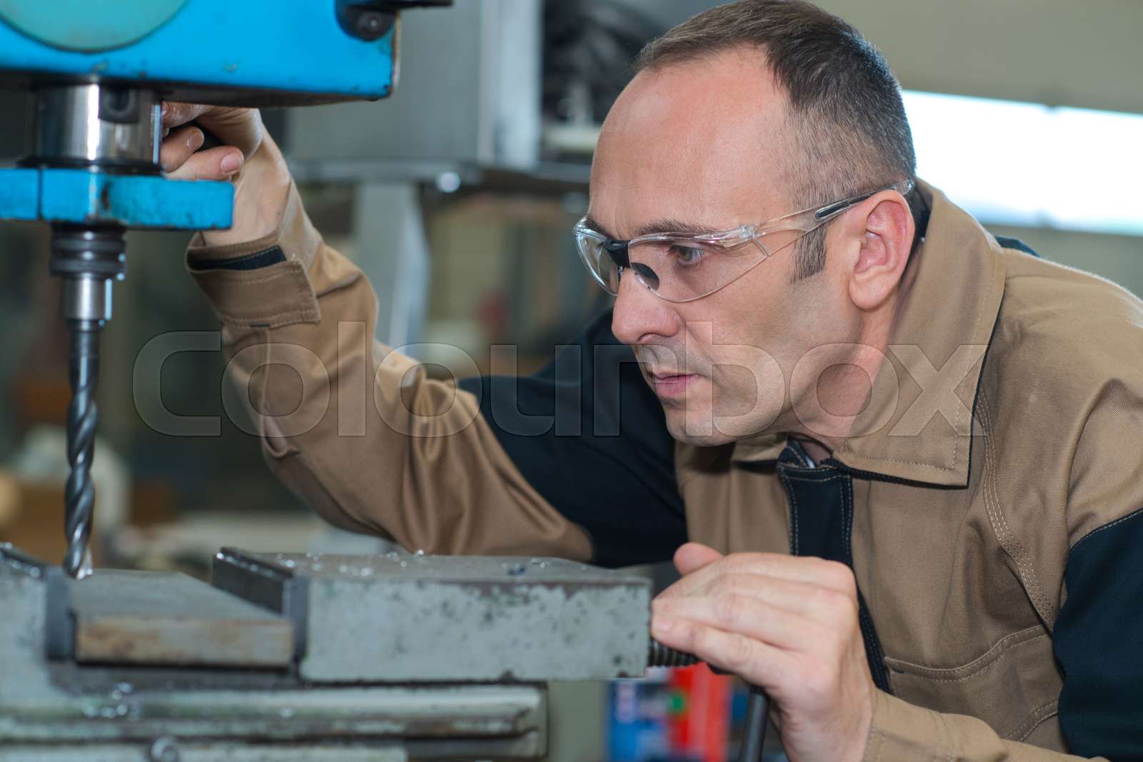mature man using a drilling machine at industrial factory | Stock image ...