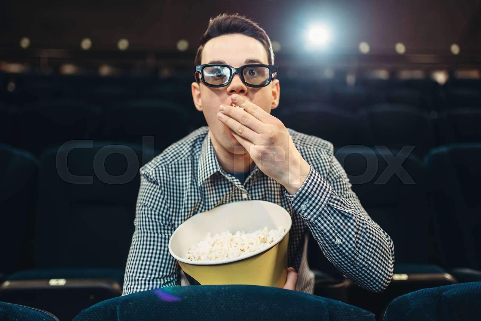 Teenager fascinated watching the film in cinema | Stock image | Colourbox