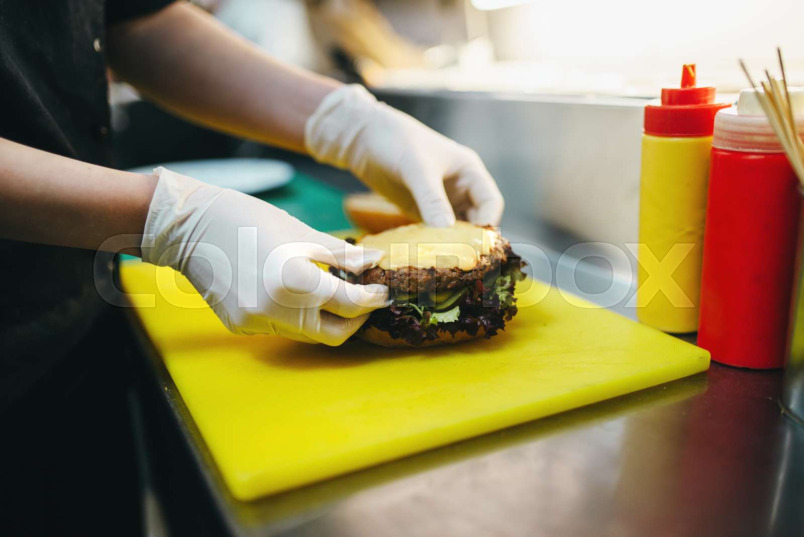 Male cook prepares fast food, burger preparation | Stock image | Colourbox