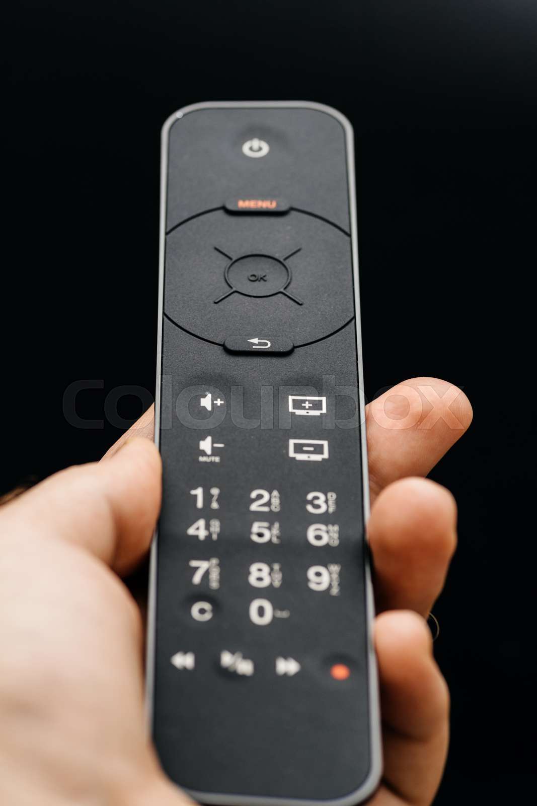 Male hand holding modern wireless remote control | Stock image | Colourbox